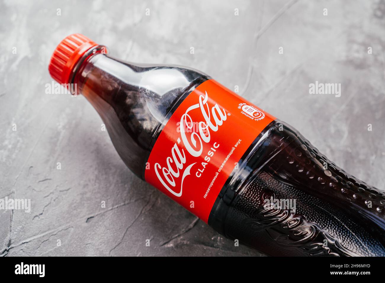Clear plastic bottle of Coca-Cola lie on gray concrete surface. Bottle ...