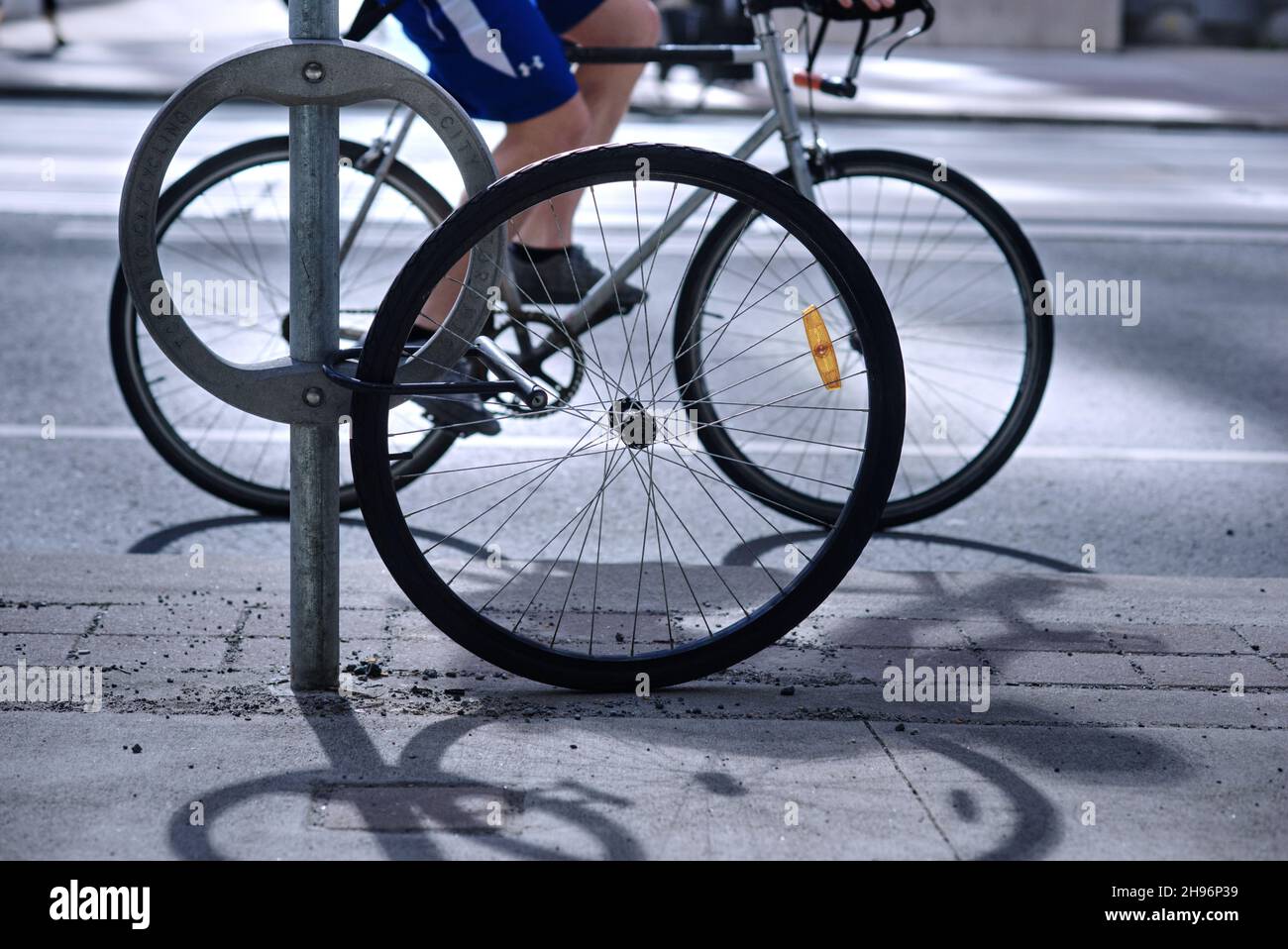 Selective of a wheel chained to the pole and a man on the bicycle Stock ... Selective of a wheel chained to the pole and a man on the bicycle Stock ...