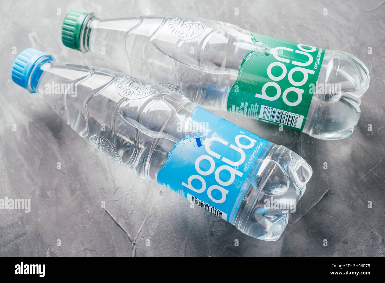 Plastic bottles of Bonaqua mineral water lie on gray concrete surface ...