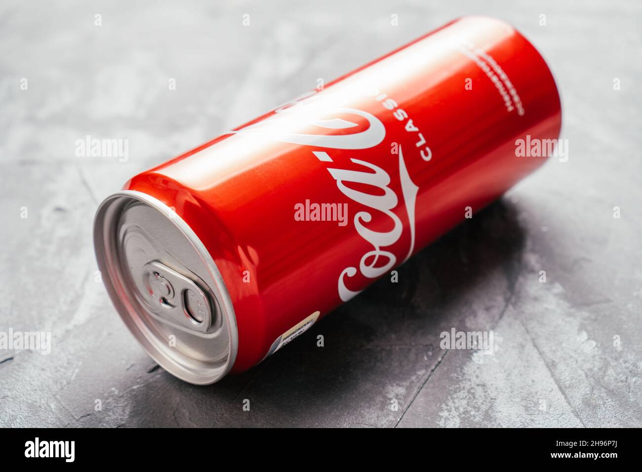 Red metal can of Coca-Cola lie on gray concrete surface. Minsk, Belarus ...