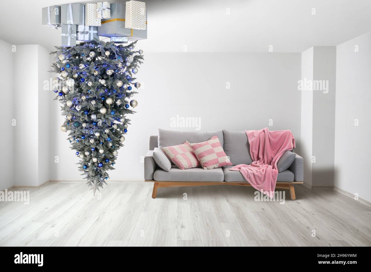 Beautiful Christmas tree with gift boxes hanging on ceiling in room ...