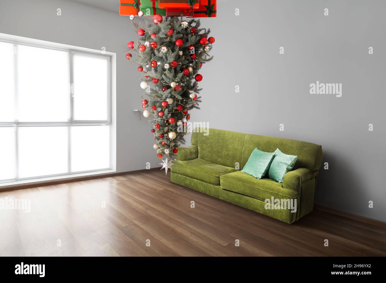 Beautiful Christmas tree with gift boxes hanging on ceiling in room ...