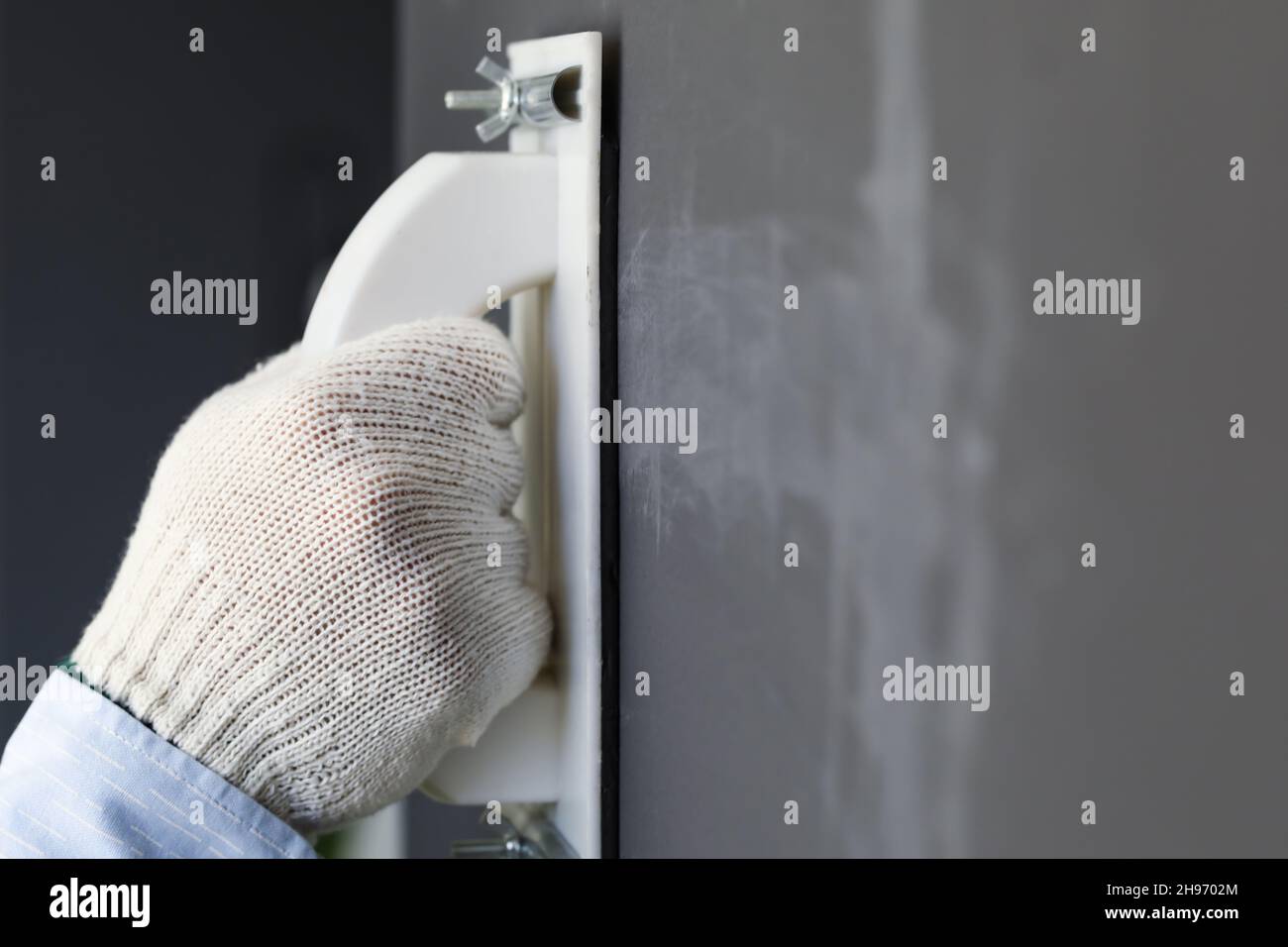 Construction worker with burnishing trowel polishing wall, closeup ...