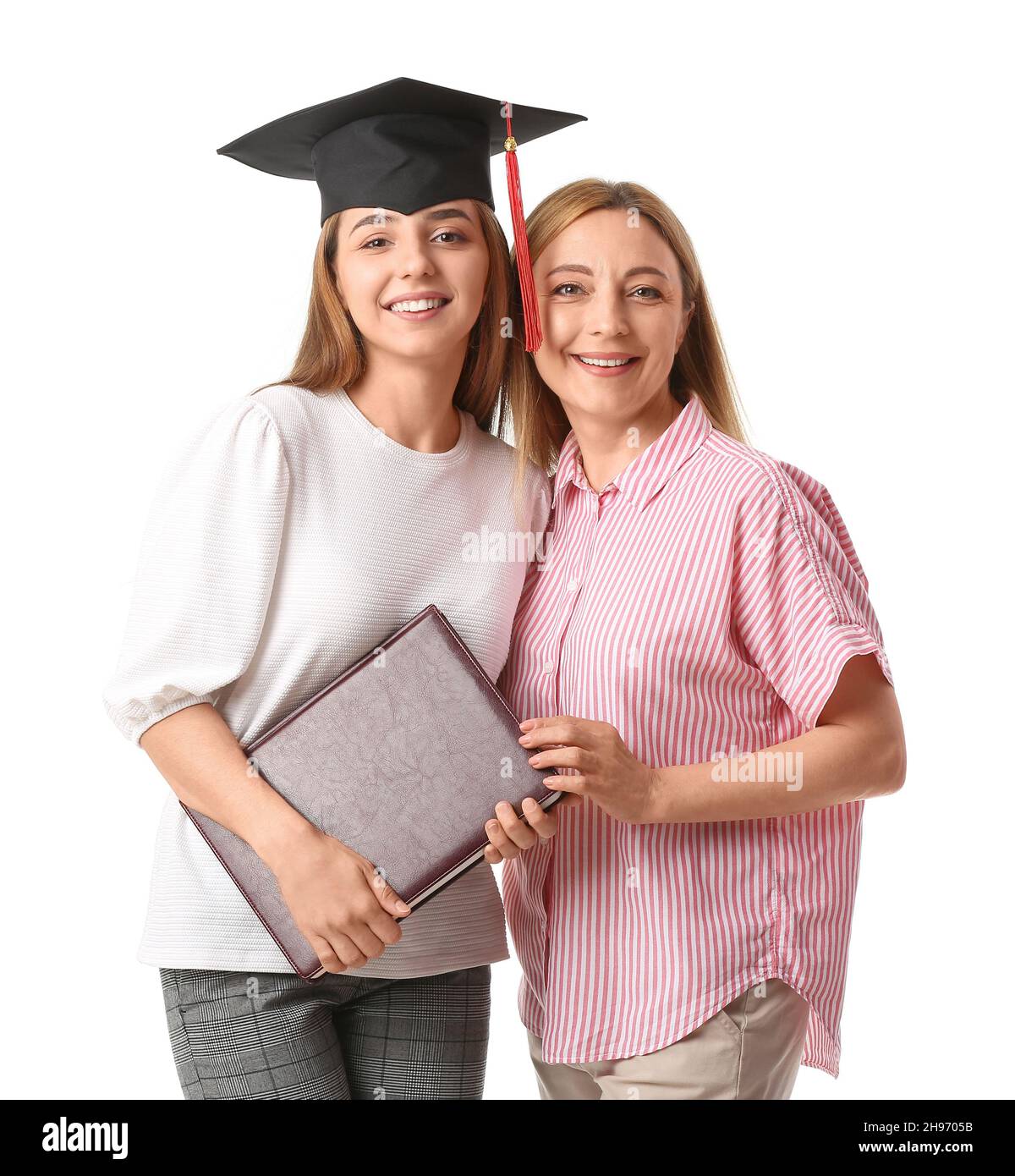 Happy female graduation student with her mother on white background ...