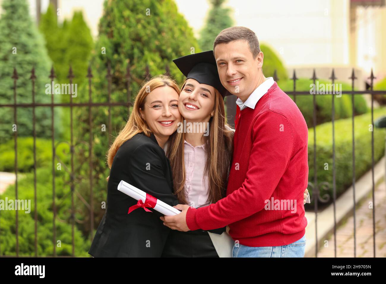Happy young woman with her parents on graduation day Stock Photo - Alamy