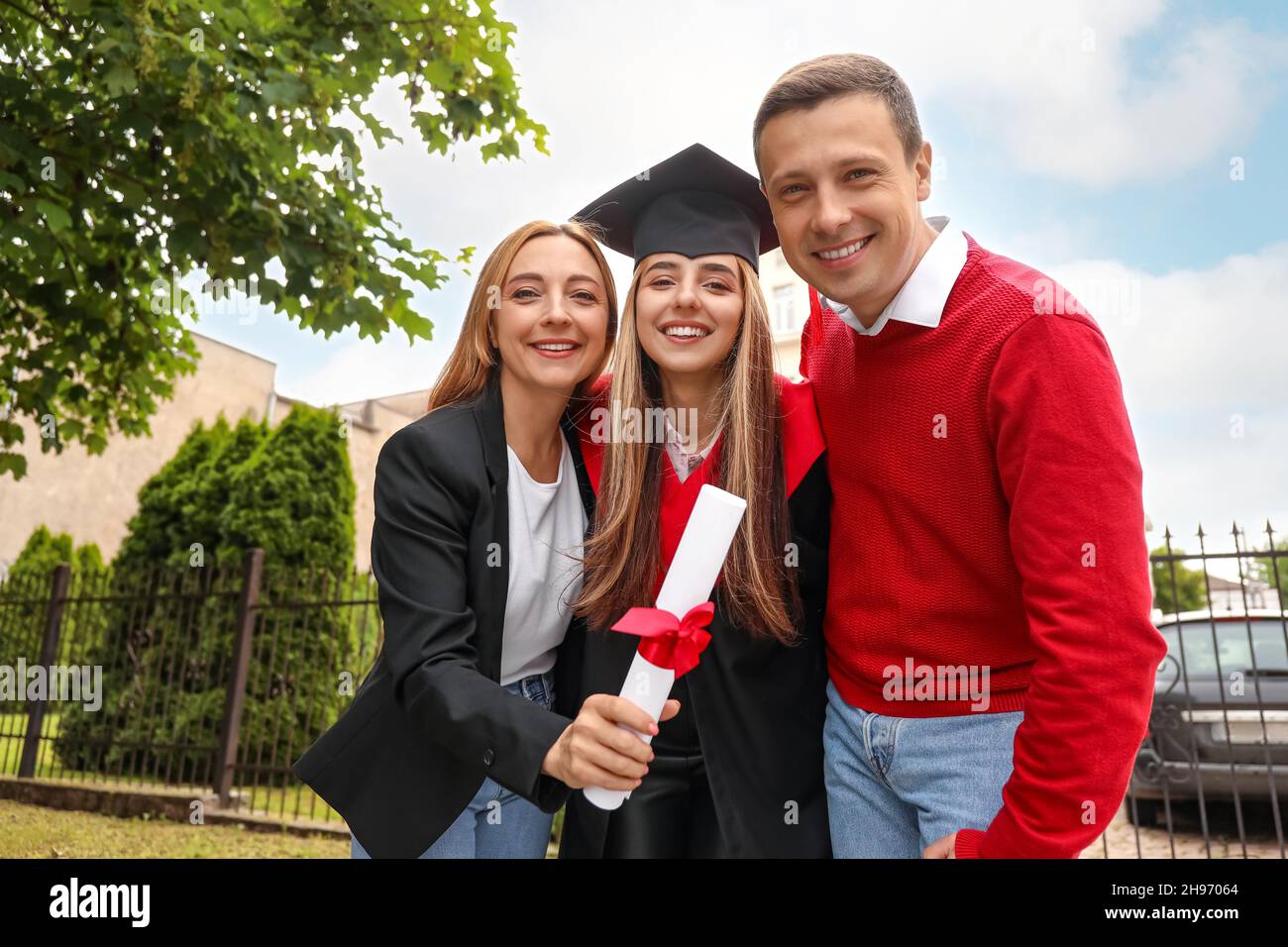 Happy young woman with her parents on graduation day Stock Photo - Alamy