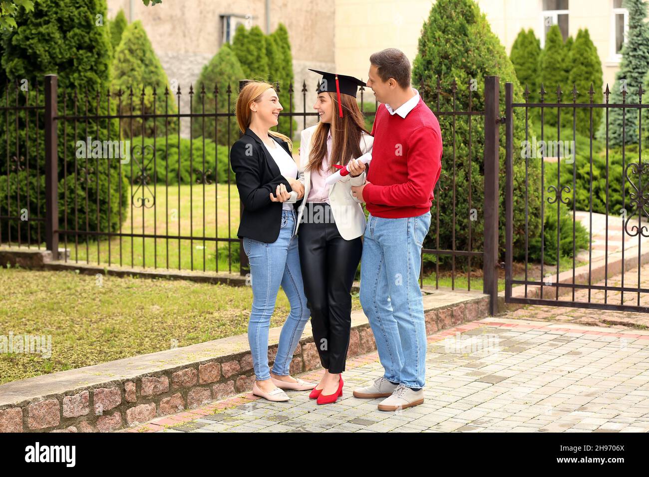 Happy young woman with her parents on graduation day Stock Photo - Alamy