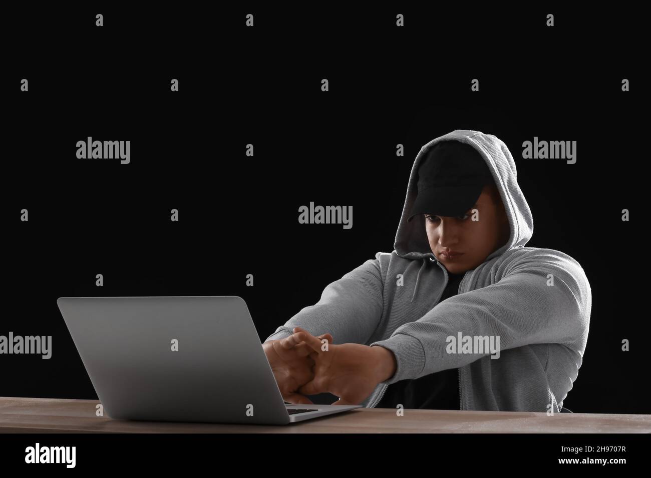 Hacker with laptop on dark background Stock Photo - Alamy