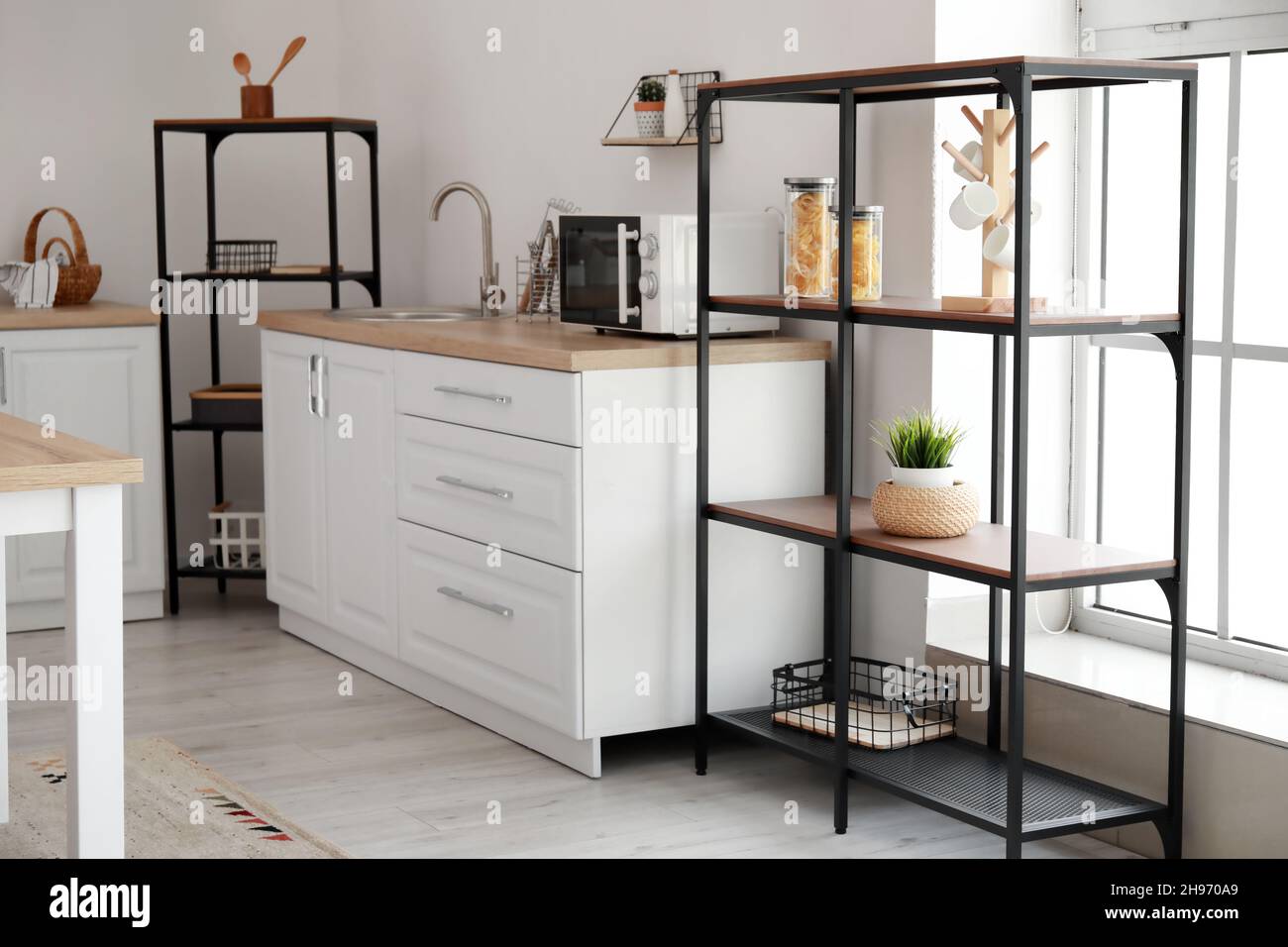 Interior of light kitchen with white counters, food and shelving units ...
