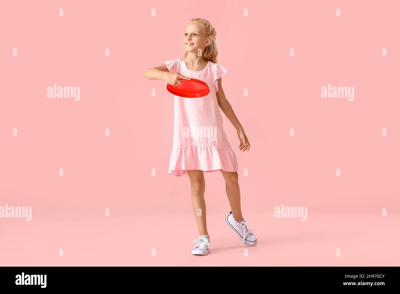Funny little girl playing frisbee on color background Stock Photo - Alamy