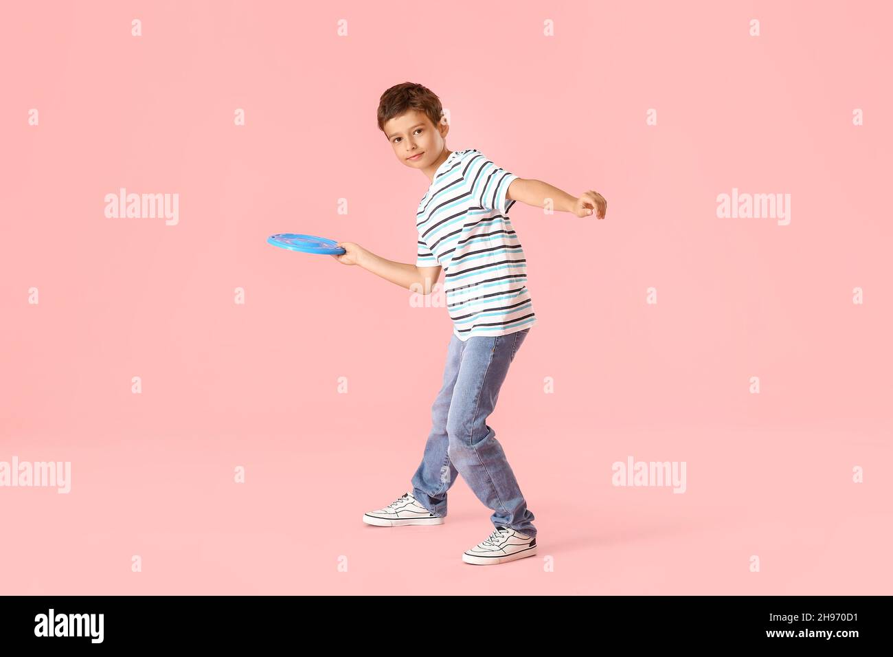 Funny little boy playing frisbee on color background Stock Photo - Alamy