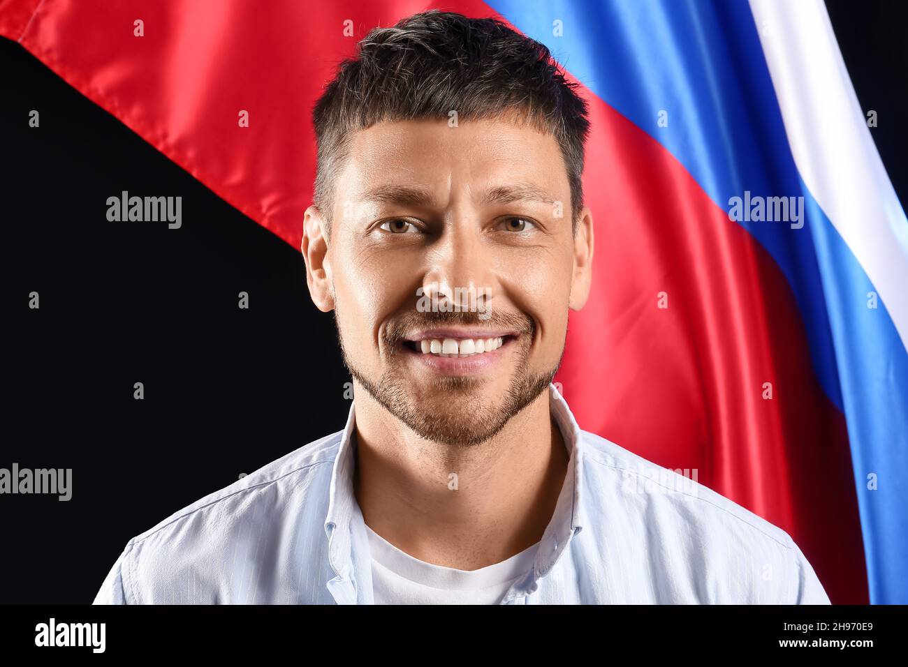 Handsome man with flag of Russia on dark background Stock Photo - Alamy