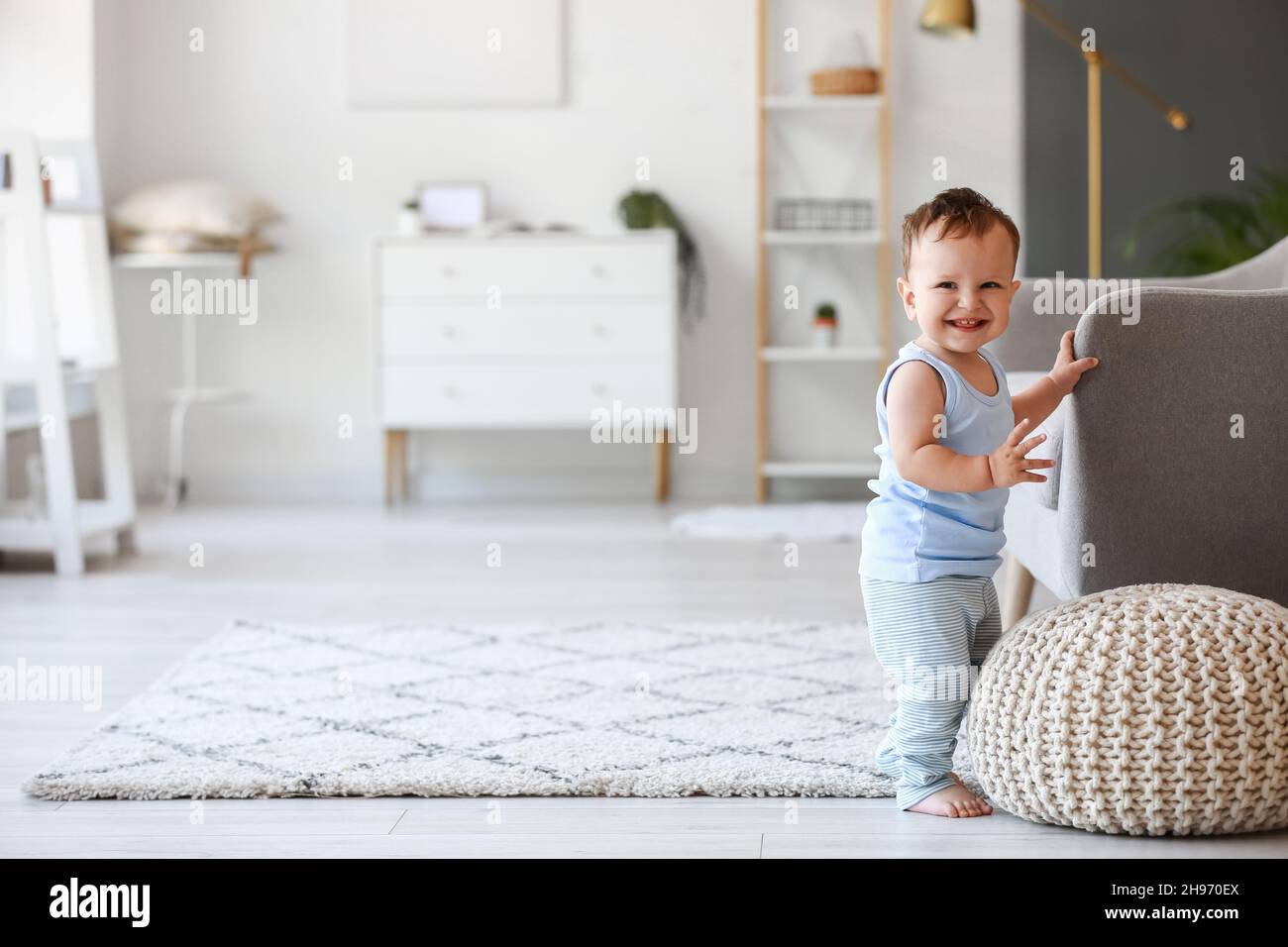 Little baby boy learning to walk near sofa at home Stock Photo - Alamy