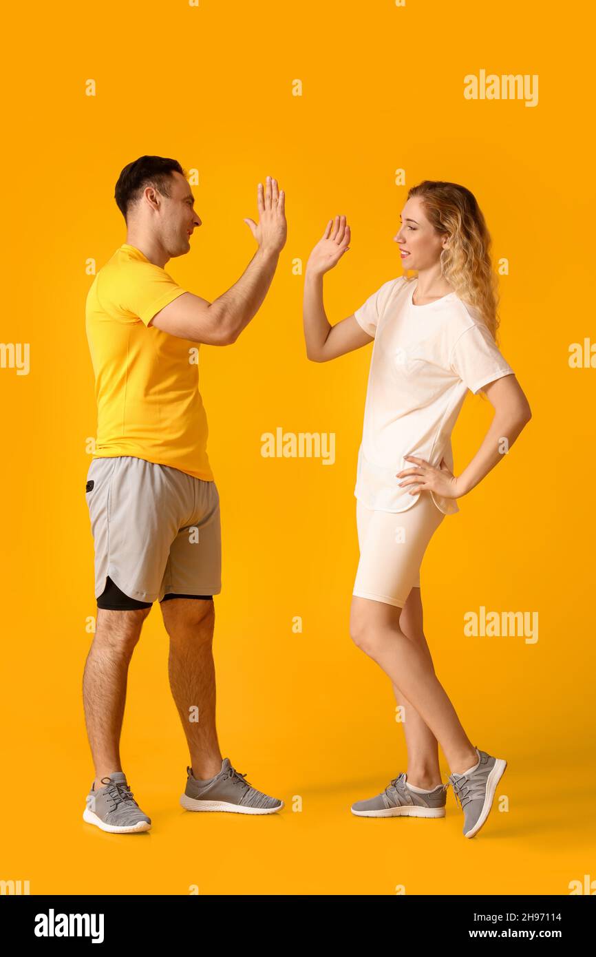 Sporty couple giving each other high-five on color background Stock ...