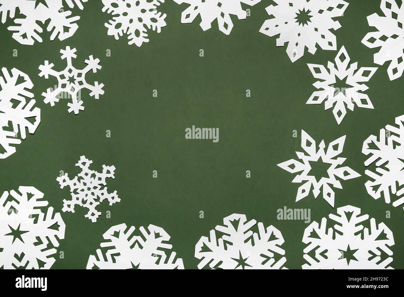 Frame made of beautiful paper snowflakes on green background Stock ...
