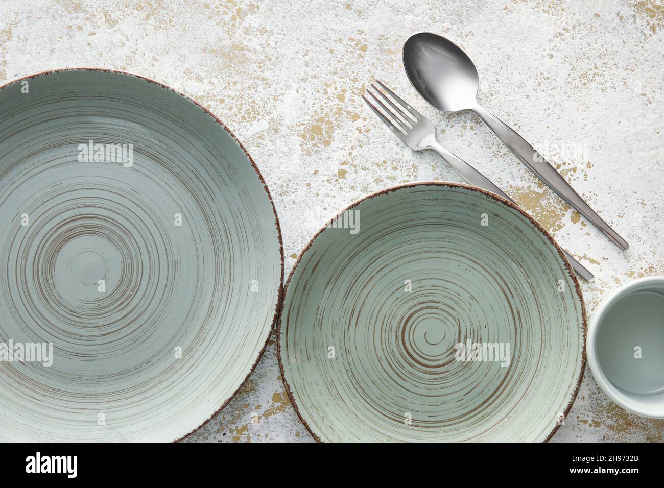 Set of stylish dinnerware on light grunge background Stock Photo - Alamy