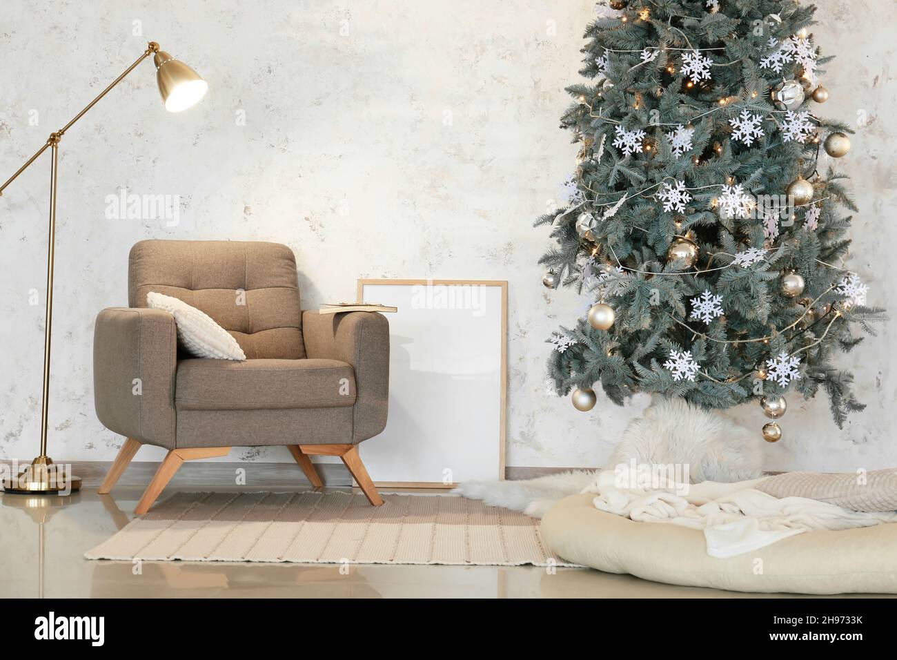 Interior of light room with Christmas tree, armchair and floor lamp ...