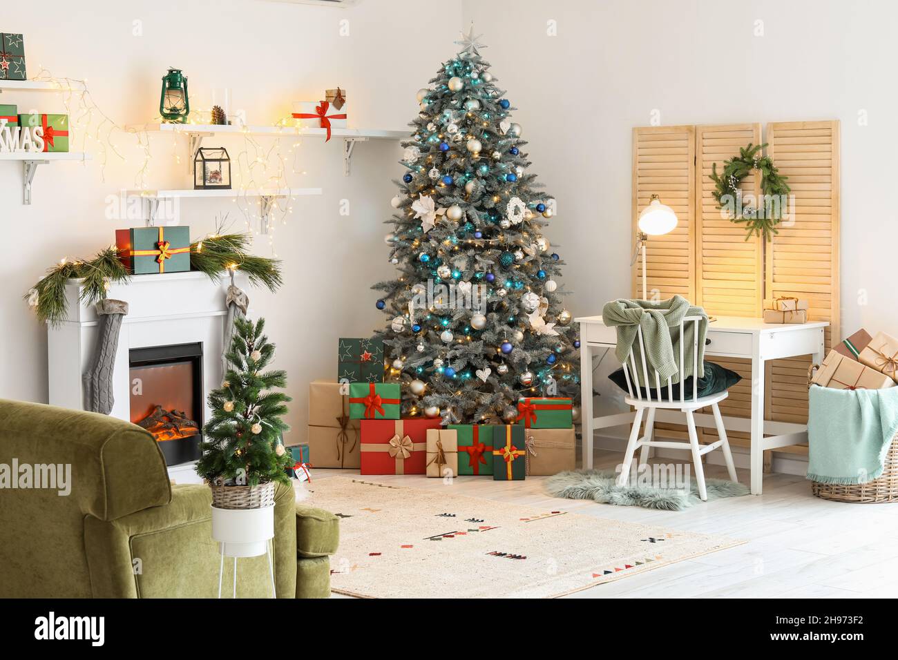 Interior of festive living room with modern workplace, Christmas trees ...