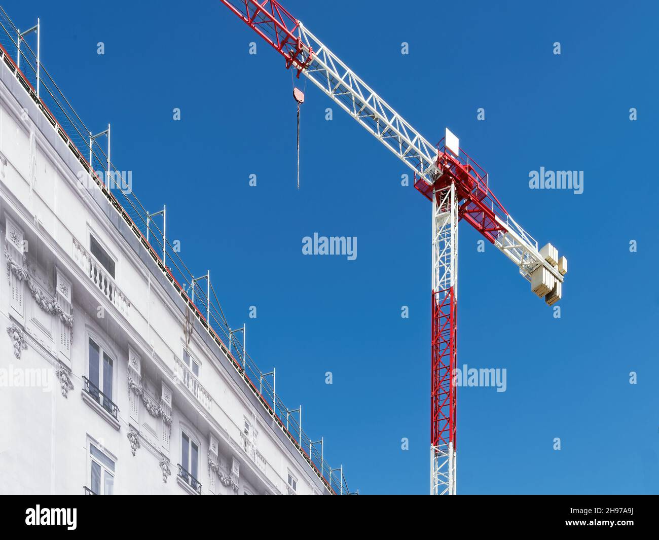 Parts of the red and white construction crane and the building with ...