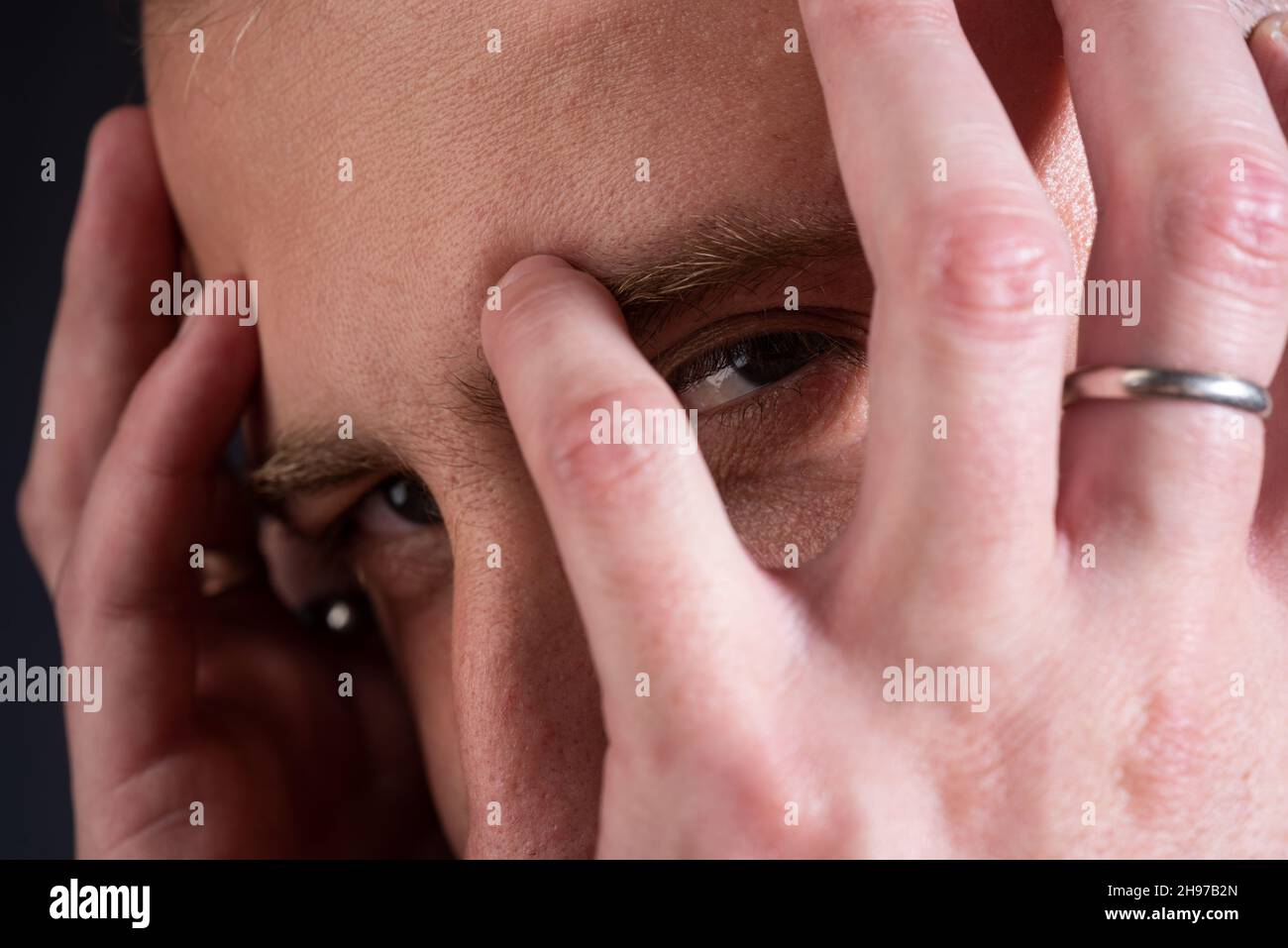 Closeup man with serious closeup face. Guy covered face with hands and ...