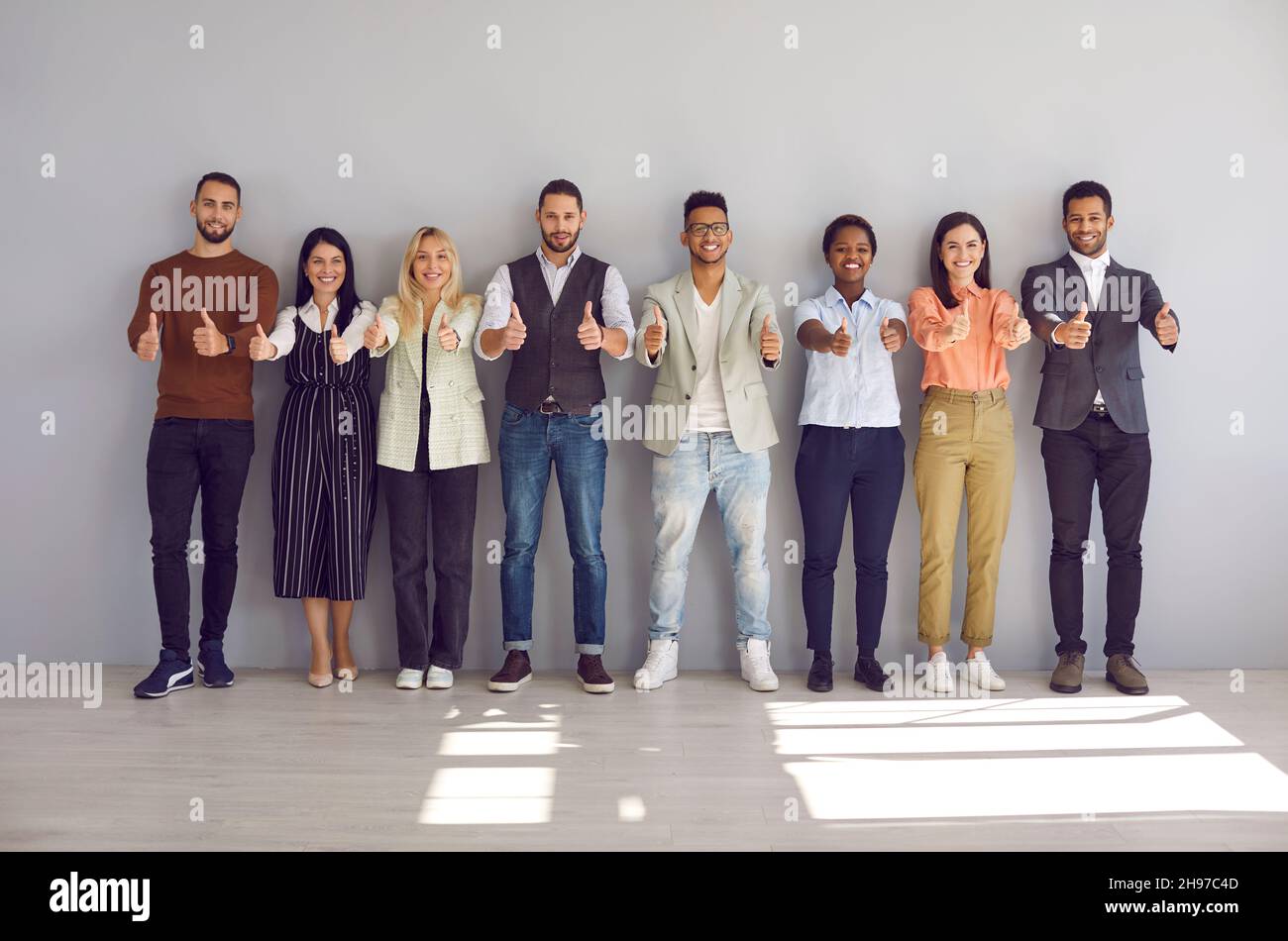 Group of diverse employees show thumbs up Stock Photo - Alamy