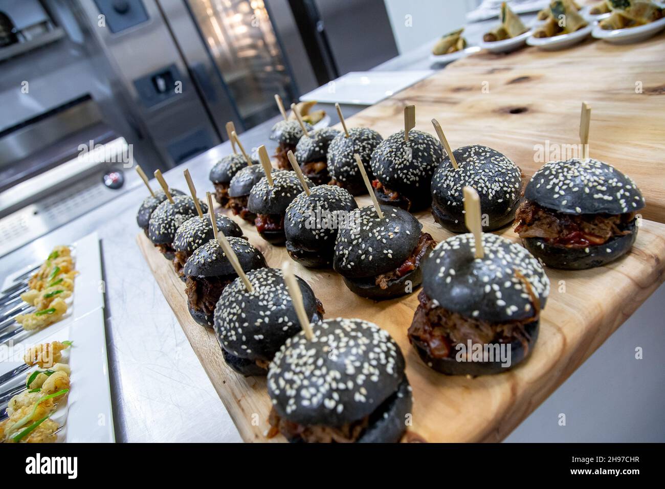 A close-up shot of delicious fancy black burgers on a wooden plate ...