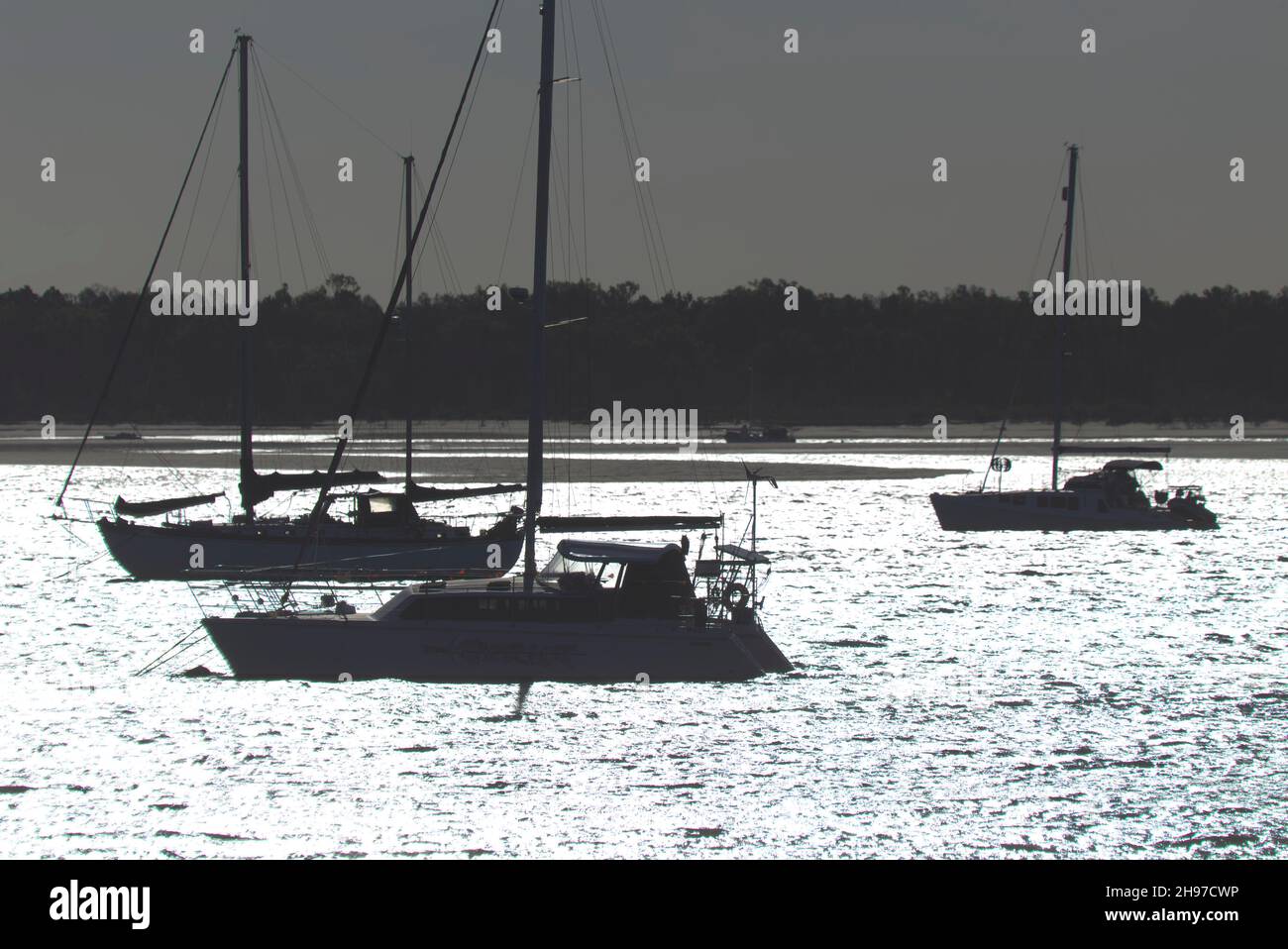 Yachts anchored in the calm waters of the Burrum River at Burrum Heads ...