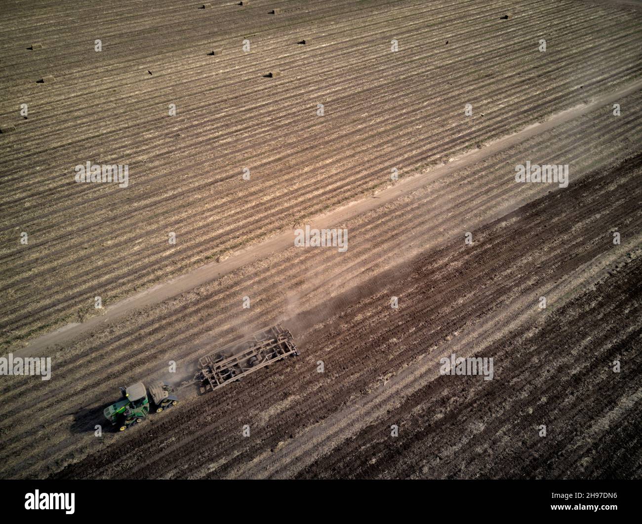 Aerial of broad acre farming tractor preparing ground for planting of ...