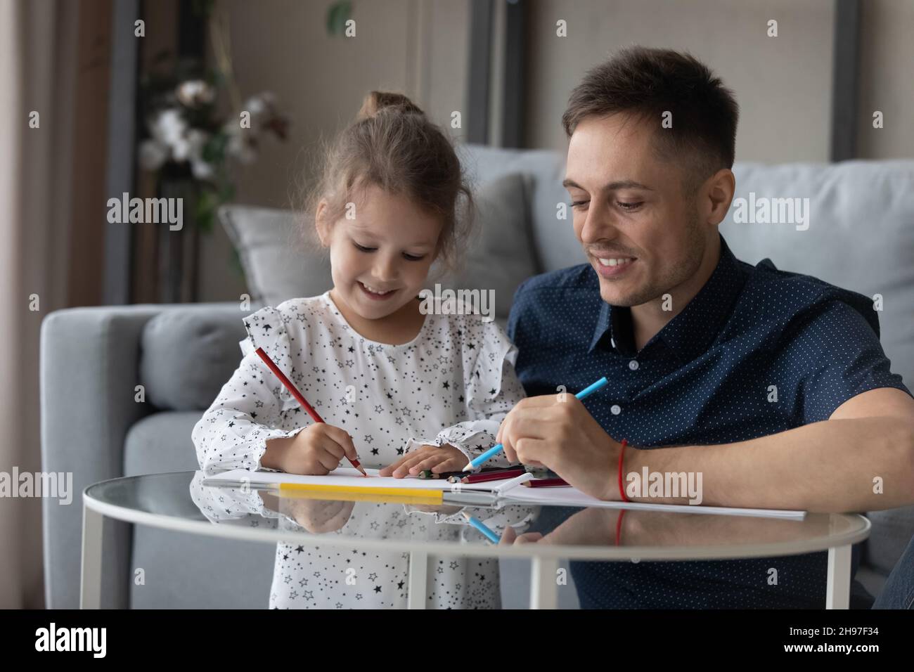 Positive dad teaching happy daughter kid to draw in pencils Stock Photo ...
