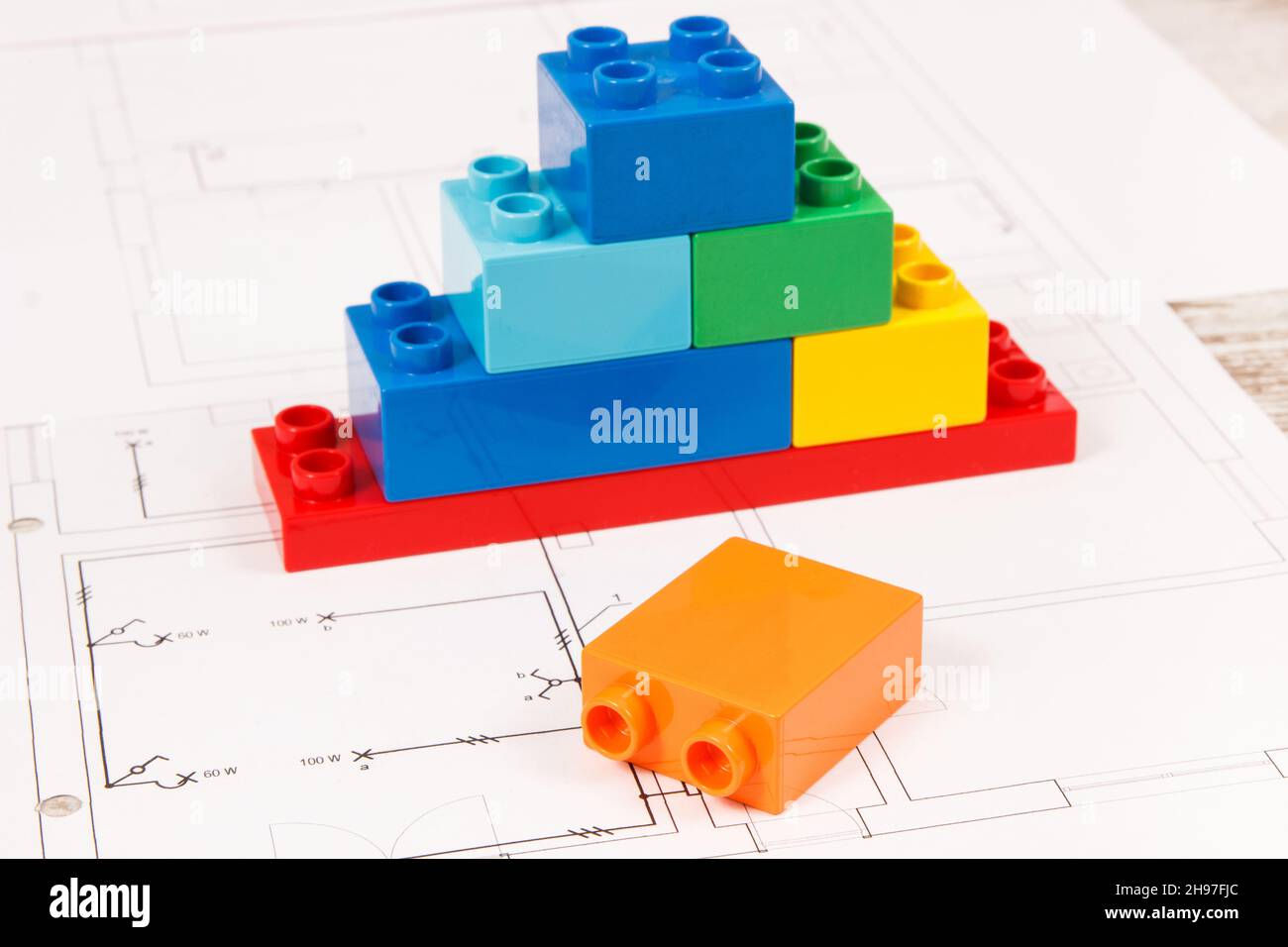 Colorful plastic toy blocks and construction housing plan. Concept of ...