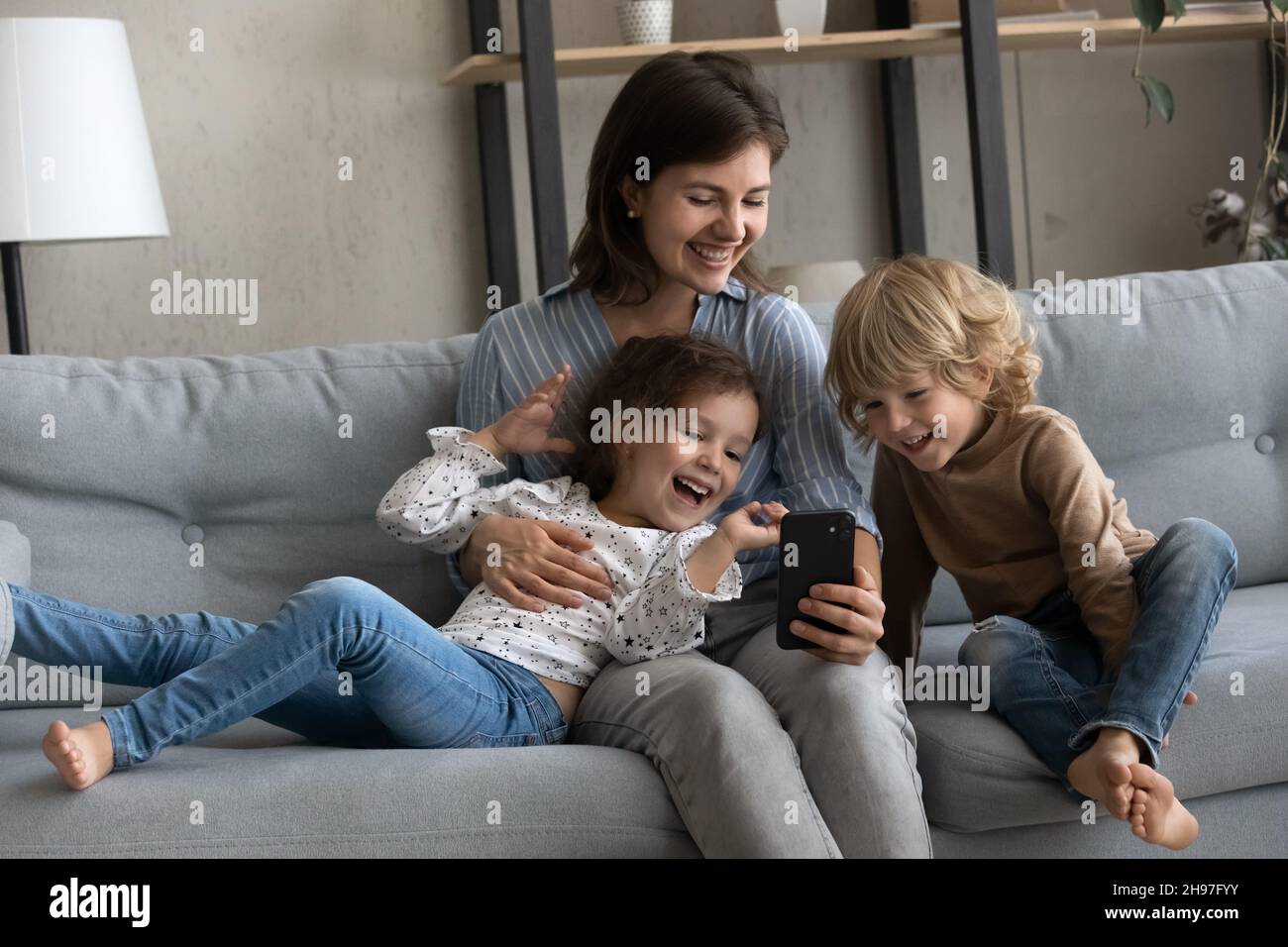 Happy mom and cheerful kids making video call on smartphone Stock Photo ...