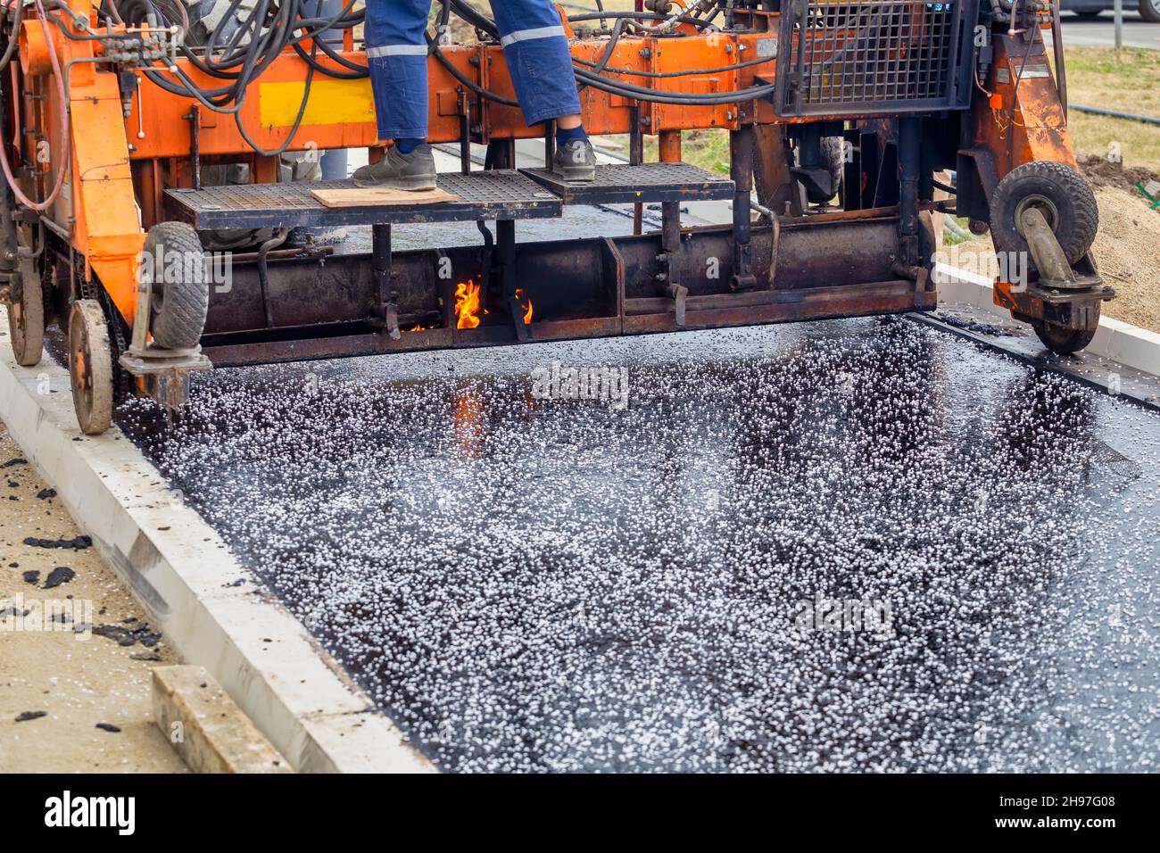 Melting asphalt with paver machine and placing gravel. Asphalt pavement ...