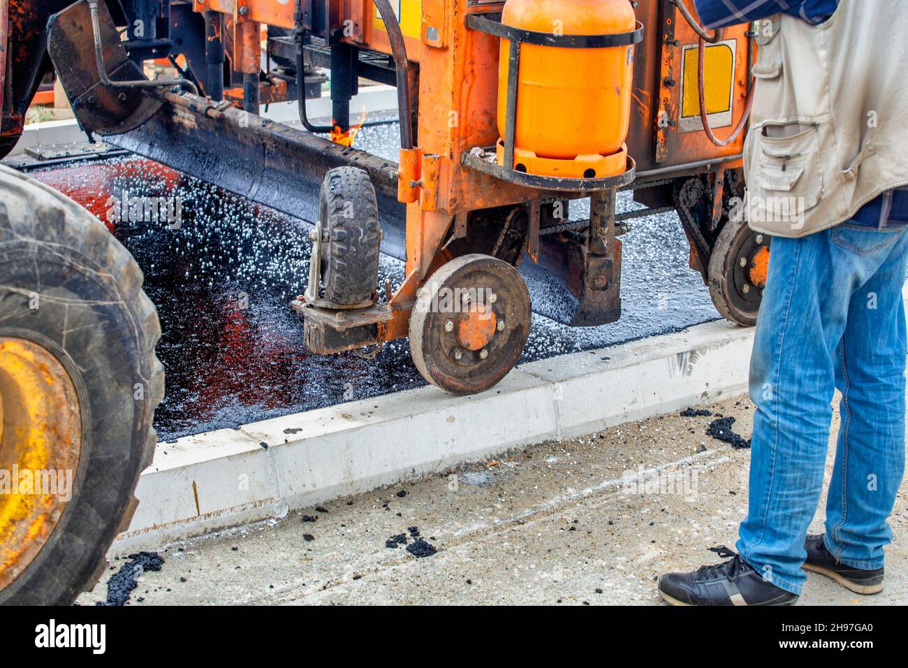 Melting asphalt with paver machine and placing gravel. Asphalt pavement ...