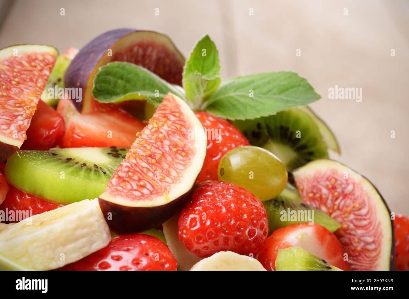 Healthy fruit mix salad on the kitchen table Stock Photo - Alamy