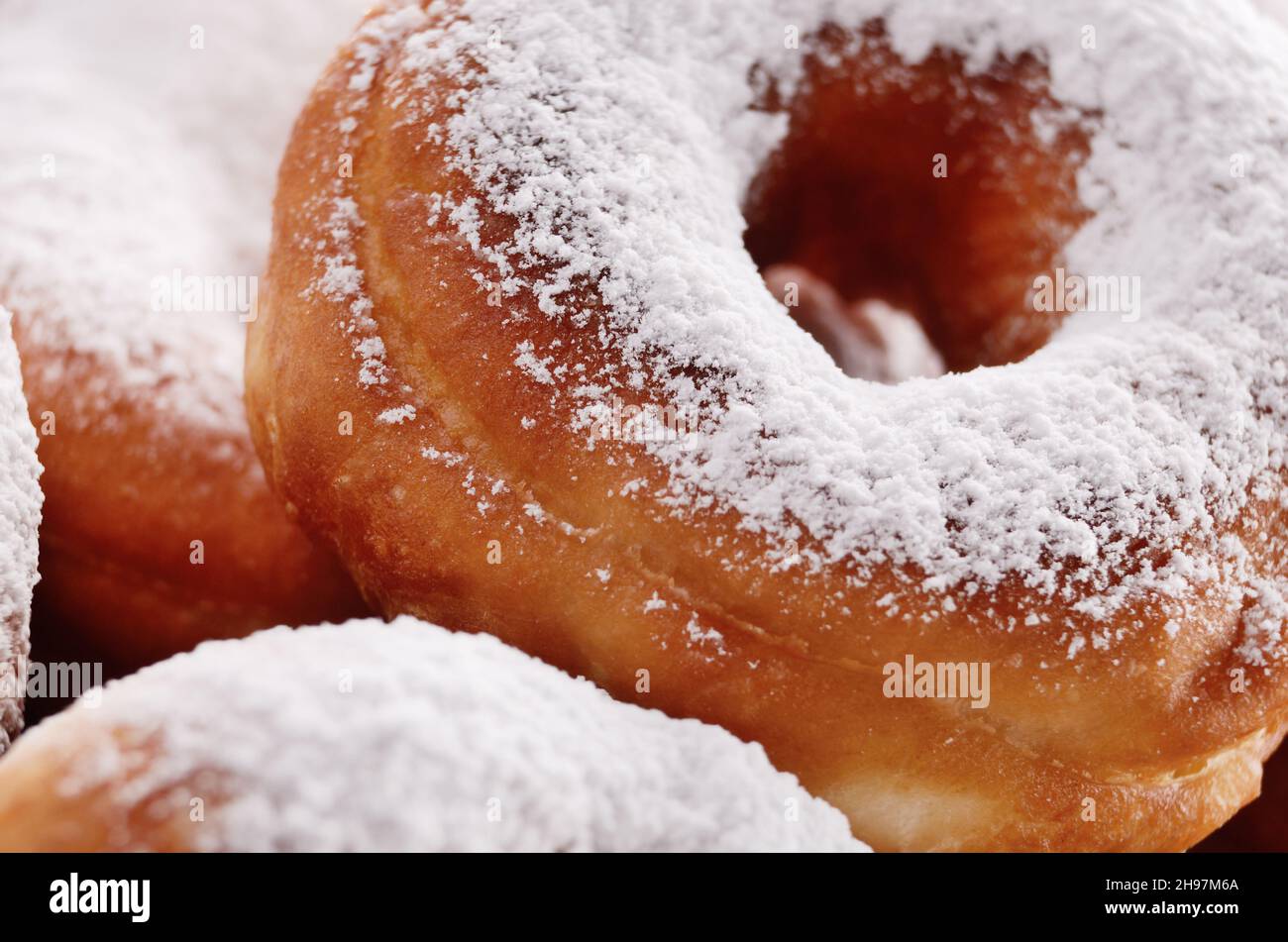 Powdered sugar crusty donuts closeup Stock Photo - Alamy