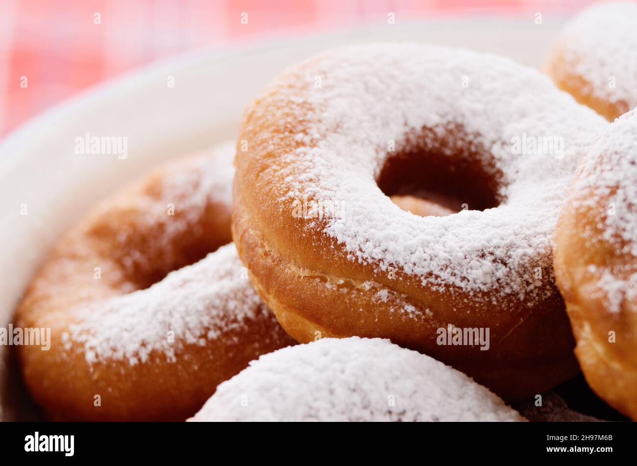 Powdered sugar crusty donuts closeup Stock Photo - Alamy