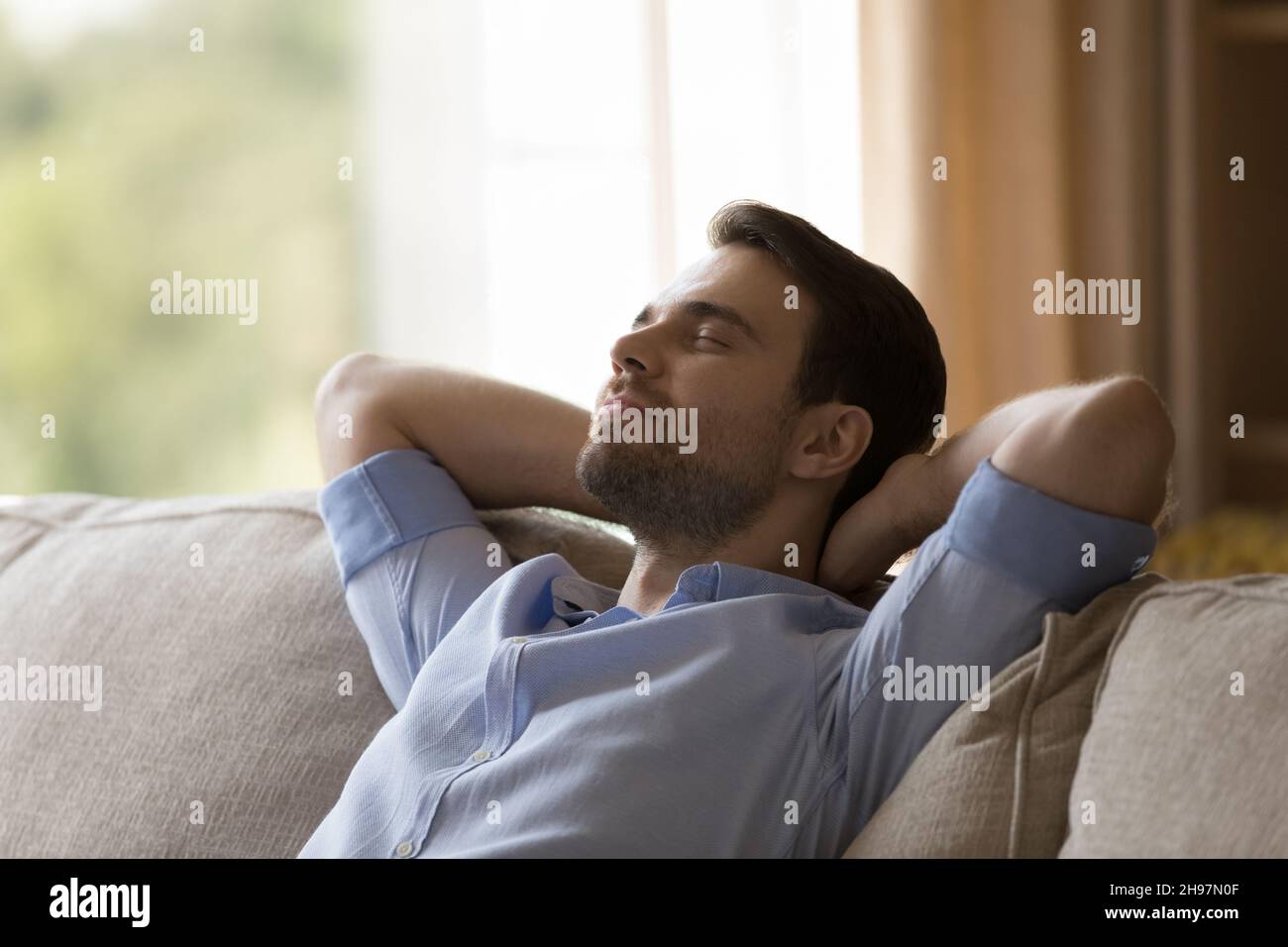 Happy dreamy young man relaxing at home Stock Photo - Alamy