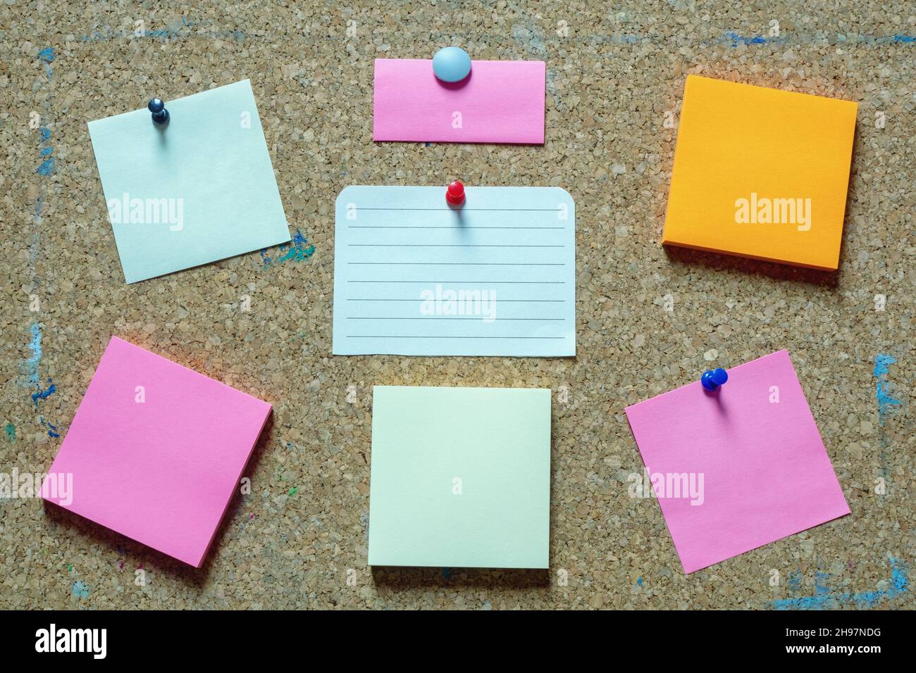 Different colorful post it notes on old cork board. Free space for text ...