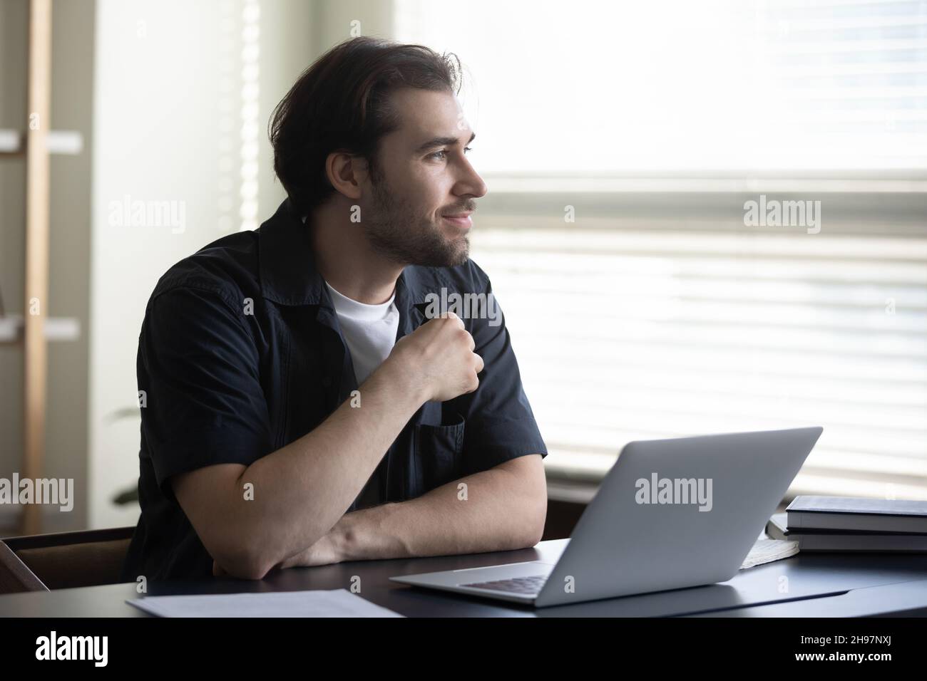 Thoughtful dreamy man thinking over work project ideas at workplace ...
