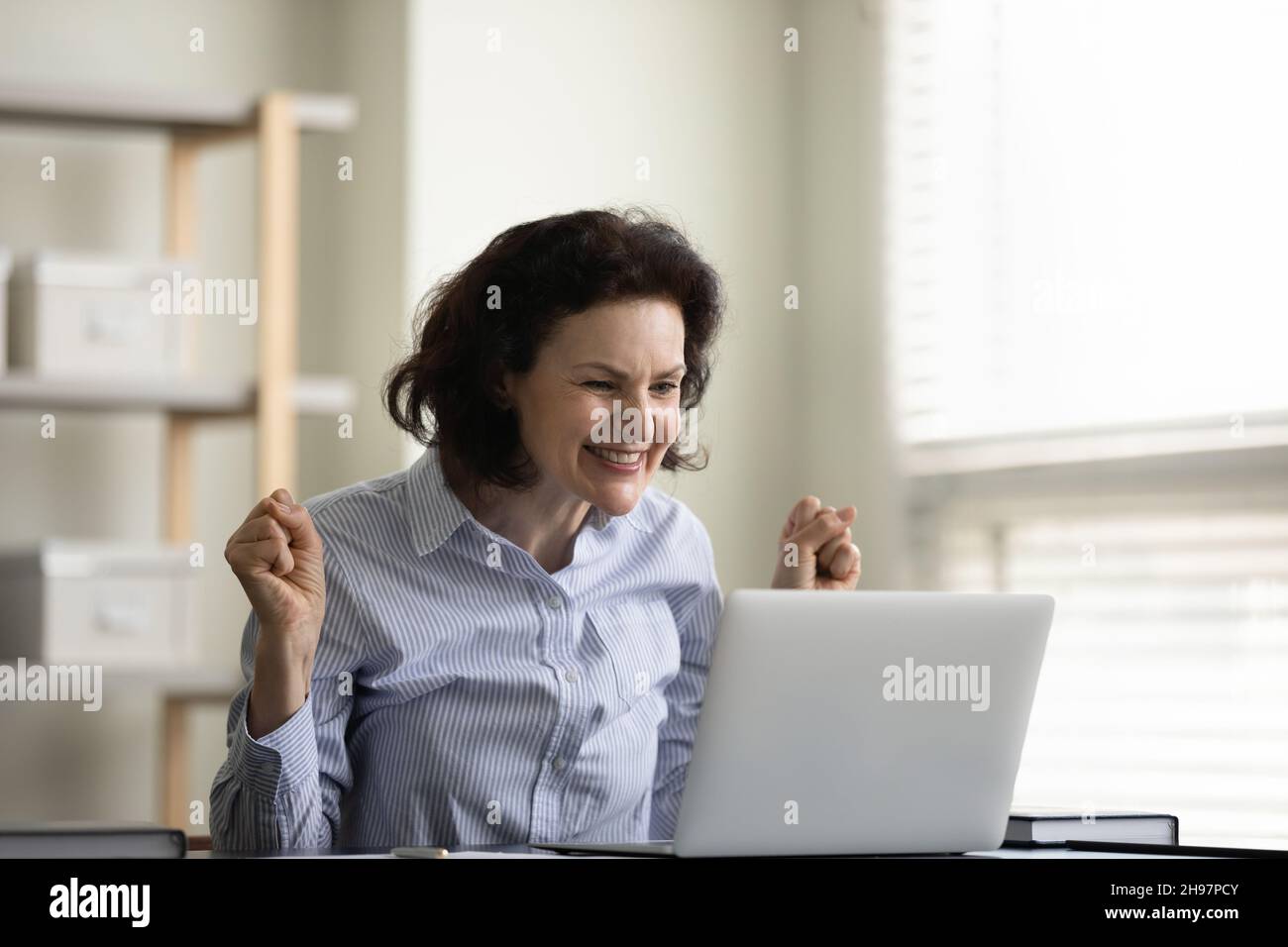 Happy excited middle aged female business leader celebrating achieve ...