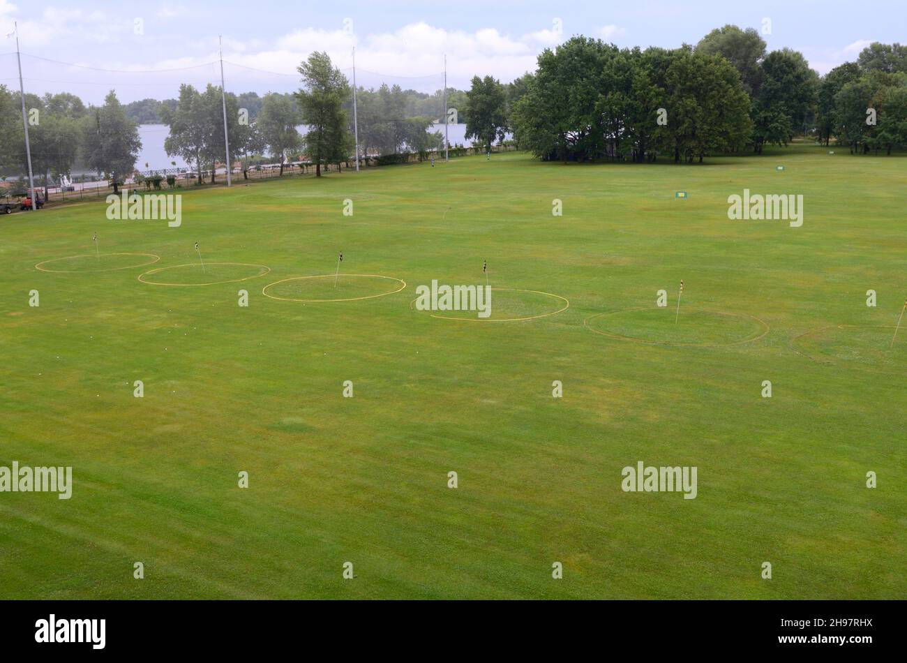 Outdoor green grass golf course with scenic of trees and riverside ...