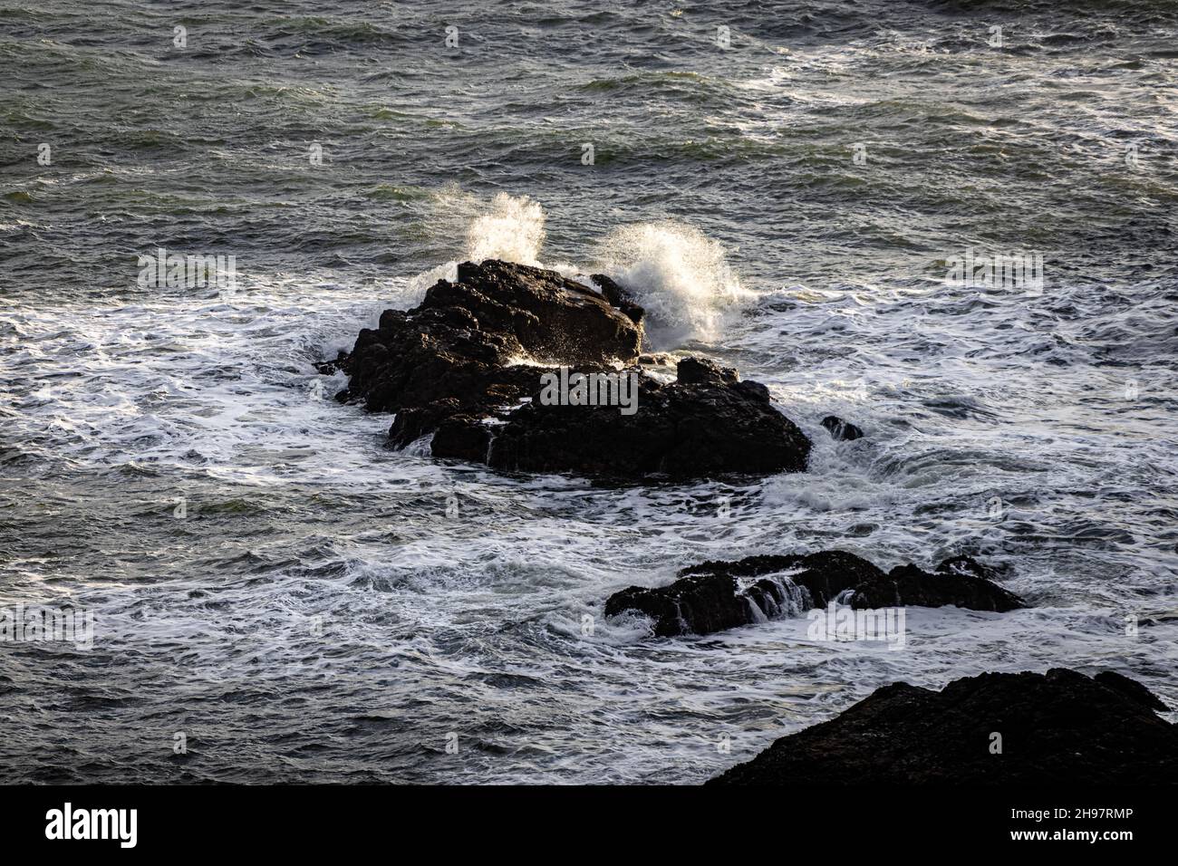 A sea wave hitting coastal rocks Stock Photo - Alamy