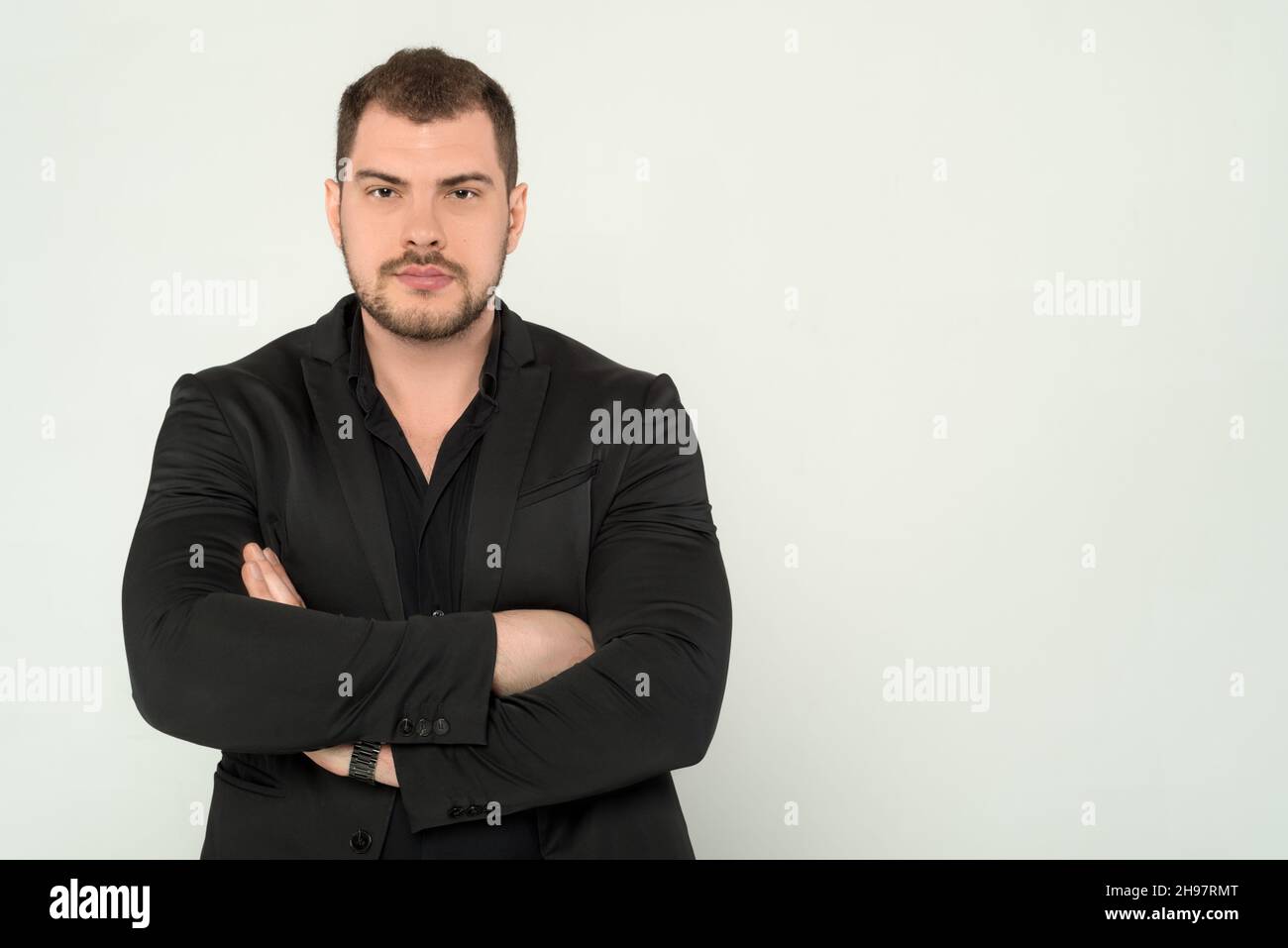 Athletically built young business man in a suit and black shirt with ...