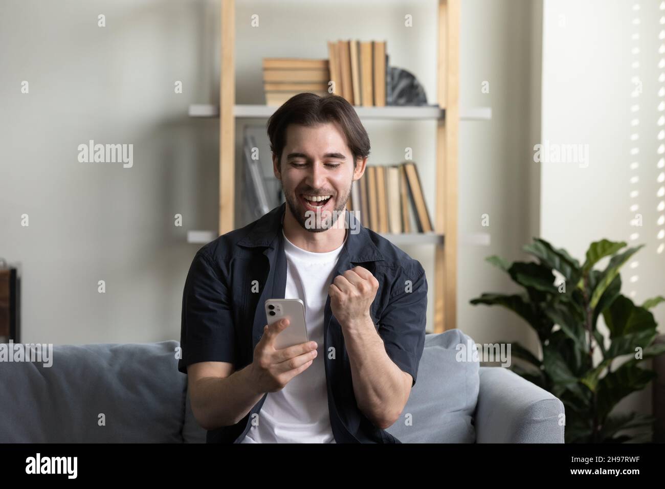 Excited mobile phone user receiving happy good news Stock Photo - Alamy