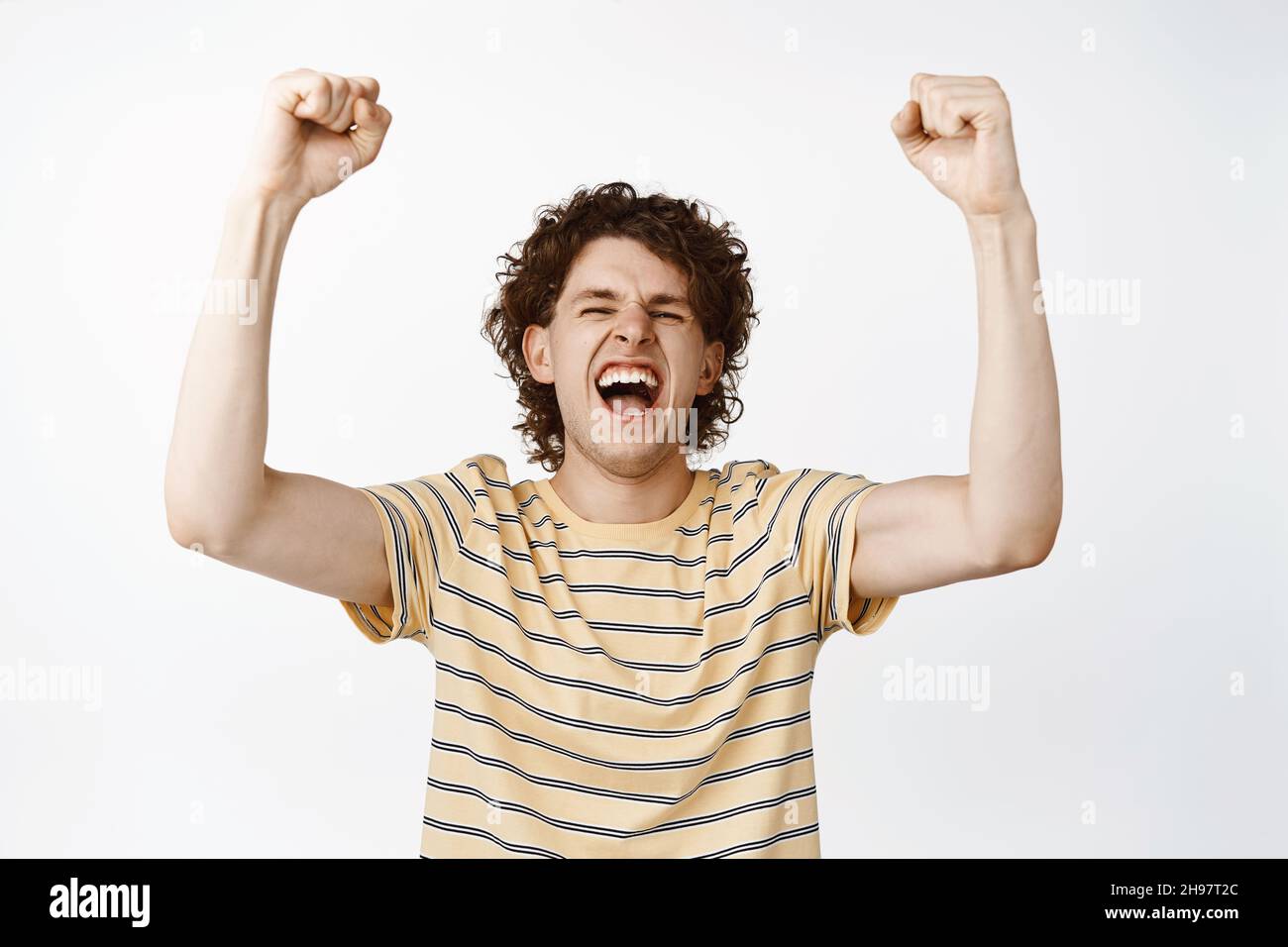 Enthusiastic young man shouting and fist pump, chanting, rooting for ...