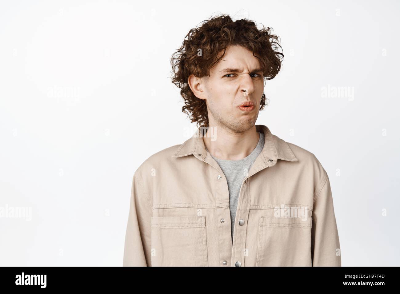 Close up of funny guy express aversion and dislike, grimacing from smth ...