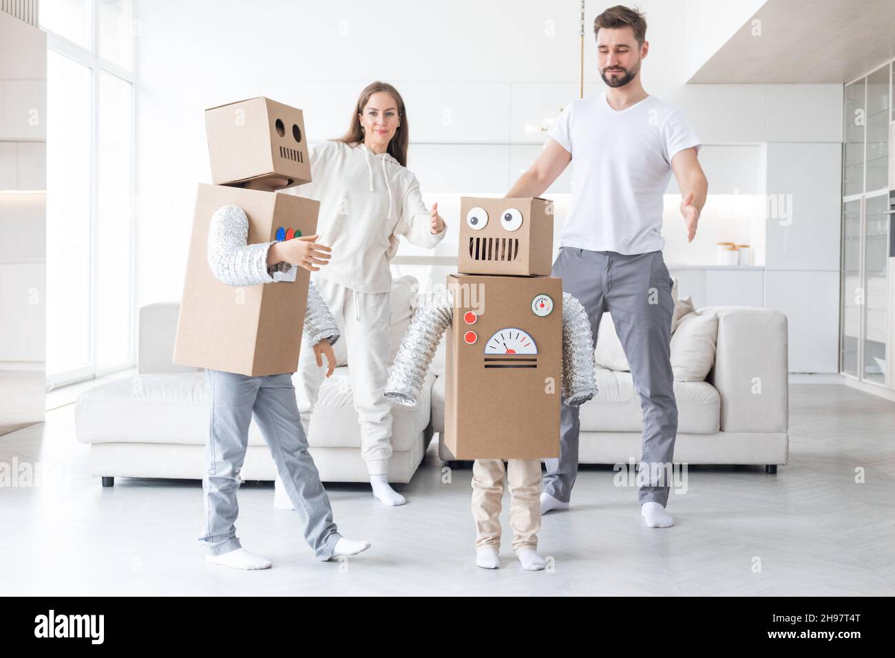 Happy family of parents and two children playing dancing like robots at ...