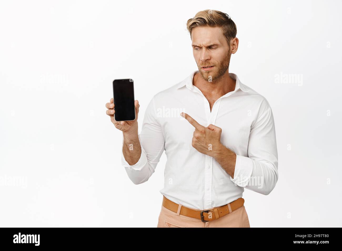 Portrait of man pointing at phone screen, showing app interface or ...