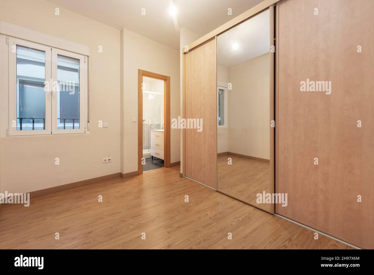 Empty furniture room with built-in wardrobe with large mirror door and ...