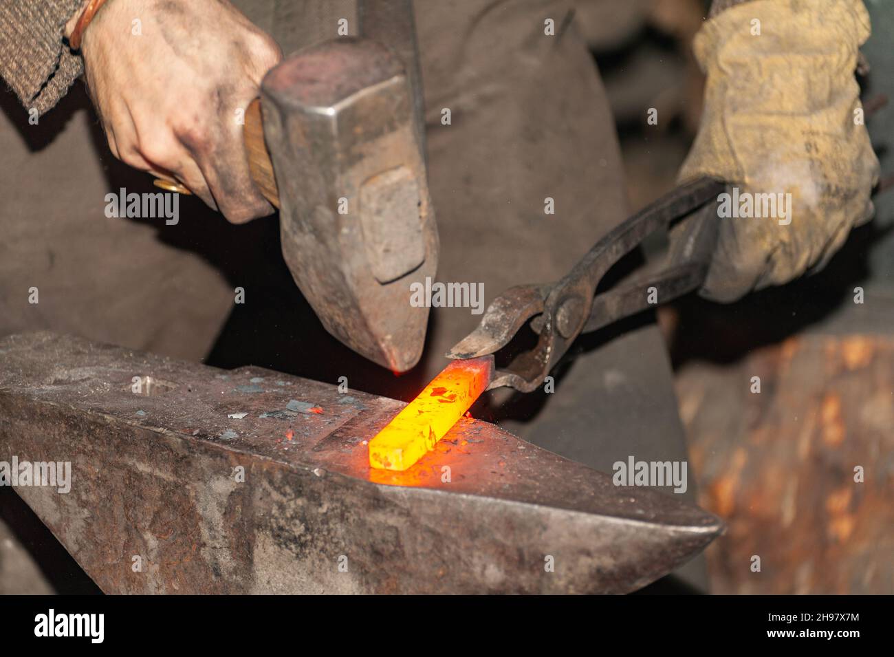 Blacksmith working metal with hammer on the anvil in the forge Stock ...